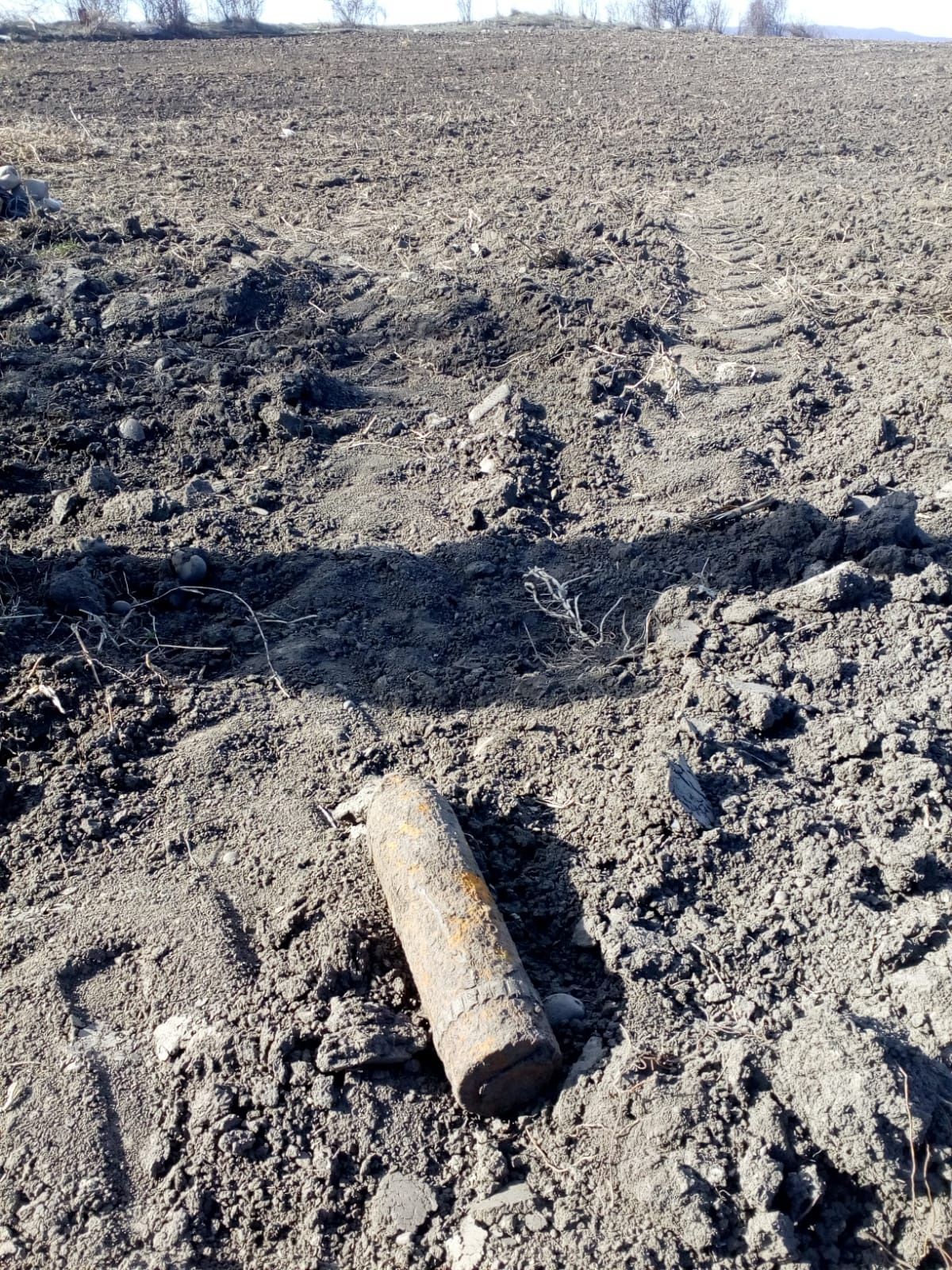 Proiectil exploziv calibru 76 mm, găsit pe un câmp în localitatea ...